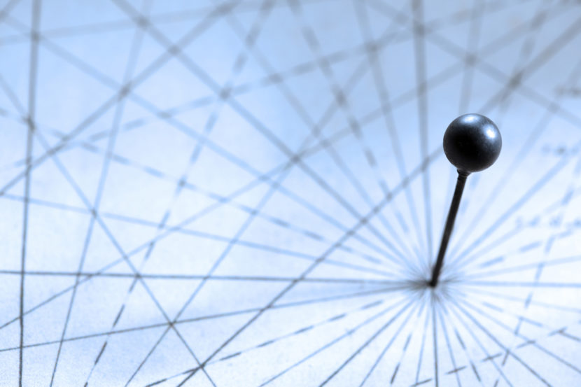 Close-up of an old push pin on an antique map – AEGIS.net, Inc.